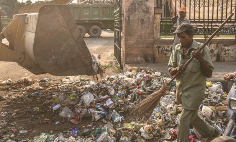 Protesting workers dump garbage in front of KMC building in Karachi ...