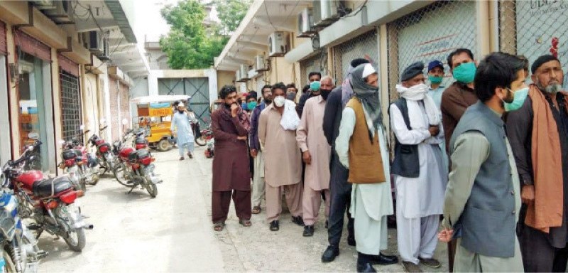 People fail to keep distance outside banks in Taxila - Newspaper - DAWN.COM