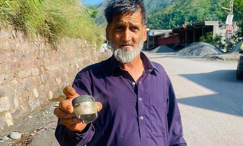 PHOTOS: A resident shows a fragment of a mortar shell after cross ...