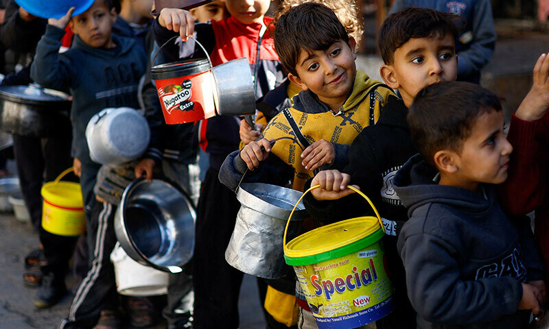 PHOTOS: Palestinians wait to receive food from a charity kitchen amid ...