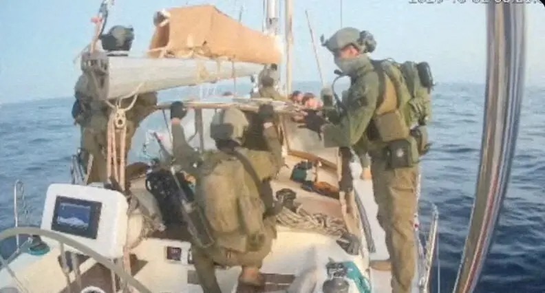 PHOTOS: Israeli soldiers point guns at flotilla members as they ...